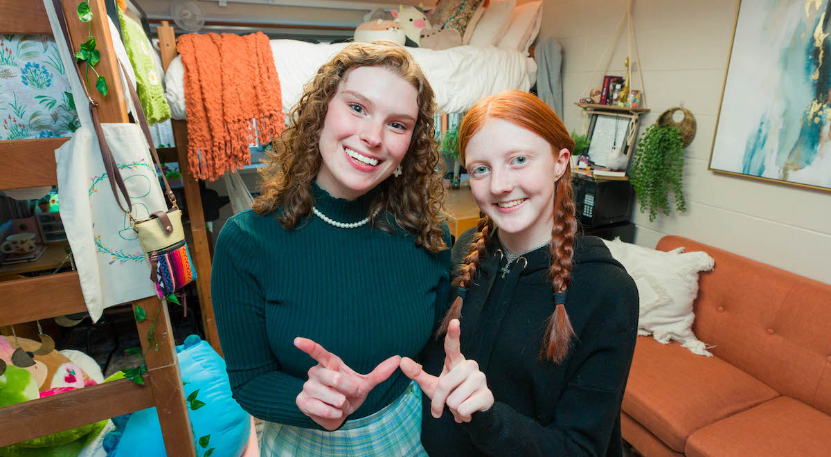 The winners of Housing's 2023 Best Room Contest making a "W" sign with ...